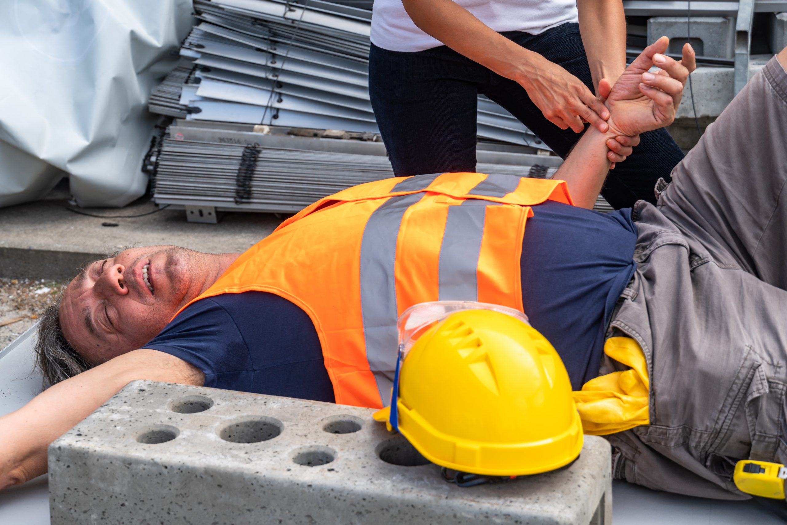 Cropped image of a paramedic’s hands checking the pulse rate of a lying ...